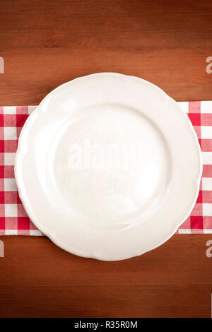 A photo of a vichy pattern cloth on a dark rustic wooden background, an ...