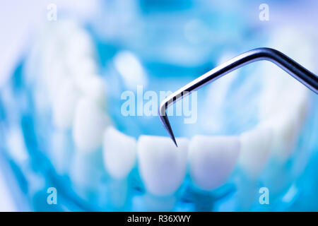 Dentist cleaning teeth with titanium metal tooth pick instrument to ...