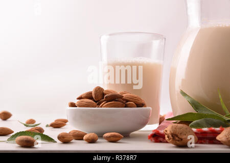 Healthy nutrition with almond drink and container with nuts on white ...