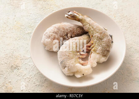 frozen king prawns without head on a plate, copy space, selected focus ...