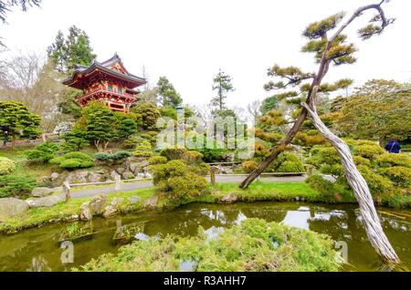 Japanese style garden with moon gate rocks shrubs and trees design by ...