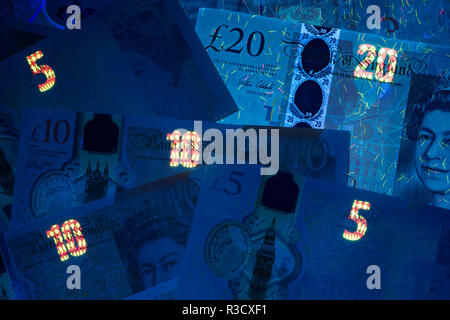 Banknote under ultraviolet light showing security features invisible in ...