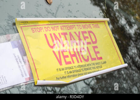 Untaxed vehicle sticker on the windscreen of a car immobilised at the ...