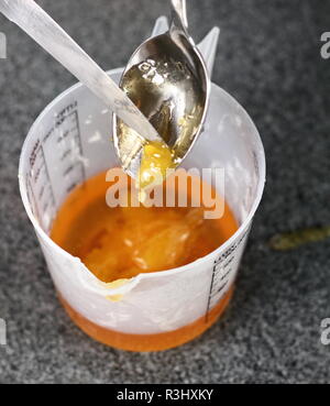 Plastic measuring cup on a gray background close up Stock Photo - Alamy