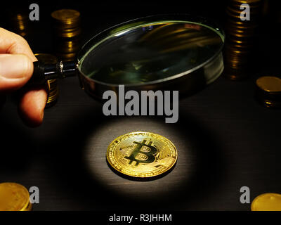 Economy concept. A man looks through a magnifying glass at charts and ...