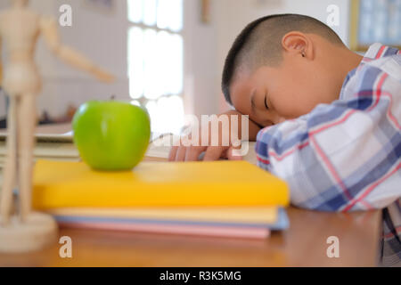 lazy stressed young little asian kid boy resting sleeping on desk ...