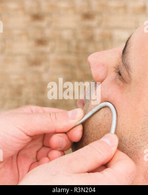 Male face epilation by the metal epistick spring in Turkey Stock Photo ...