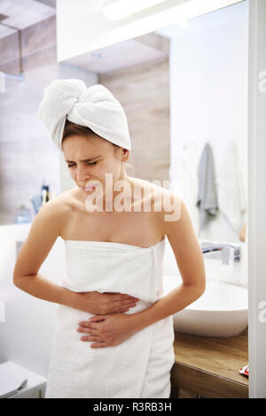 Young woman suffering from pain on toilet bowl in restroom Stock Photo ...