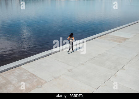 Young athletic woman running at the riverside Stock Photo - Alamy
