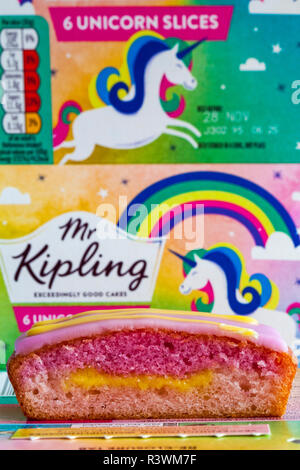 Slices of layers cake with purple fondant icing in plate on wooden ...