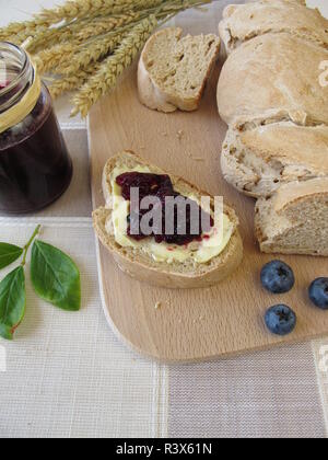 Blueberry jam on root bread for breakfast Stock Photo - Alamy