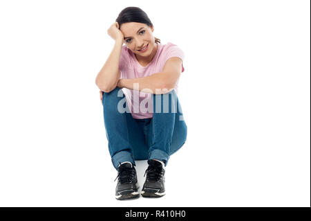 Young woman crouched on the floor Stock Photo - Alamy