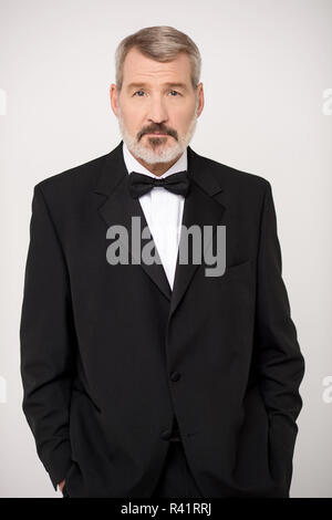 Mature handsome businessman in tuxedo thinking and looking up Stock ...