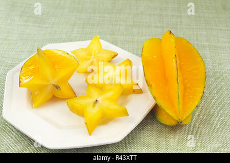 Whole and sliced fruits fresh carambola on table. Healthy vegetarian ...