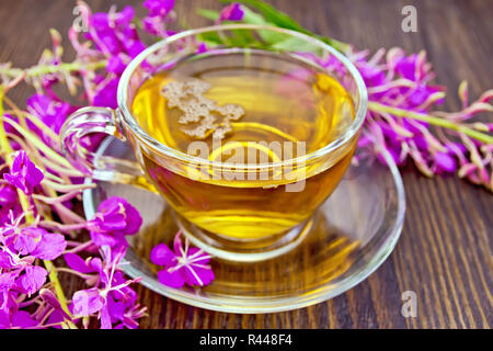 Fireweed herbal tea in the glass cup on wooden table with fresh ...