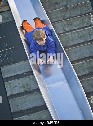 A young boy slides head first down a garden slide Stock Photo - Alamy
