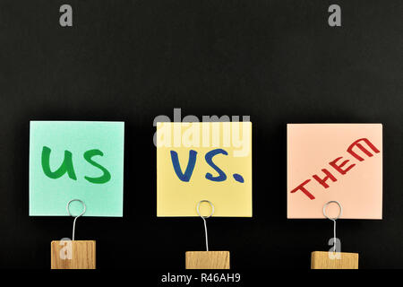 Us vs them three paper notes isolated on black Stock Photo - Alamy