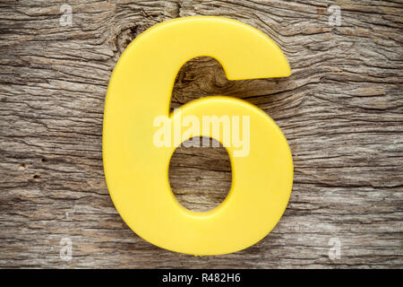 Number six yellow plastic - plastic digit on orange foamy background ...