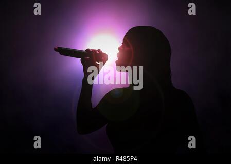 Women singing under spotlight Stock Photo - Alamy