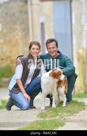 Couple of farmers with dogs around farm house Stock Photo - Alamy