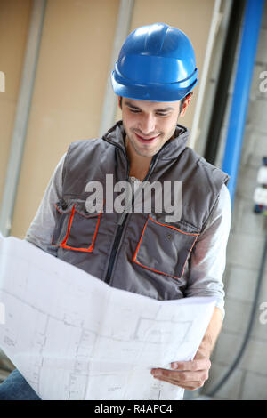 Contractor reading contruction blueprint on site Stock Photo - Alamy