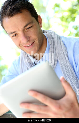 Handsome guy websurfing on internet with tablet Stock Photo - Alamy