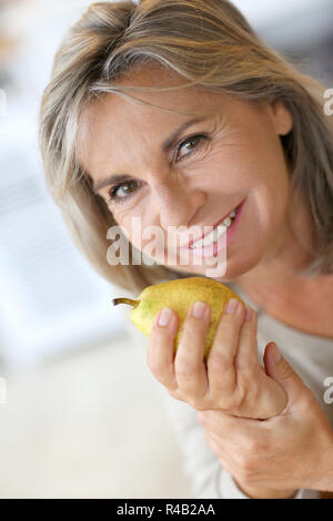 Portrait of senior woman eating pear Stock Photo - Alamy