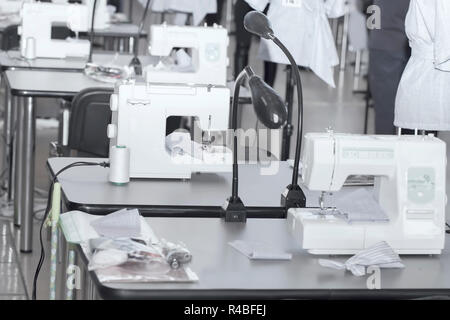 Interior of garment factory shop. Closes making atelier with several sewing machines. Tailoring ...