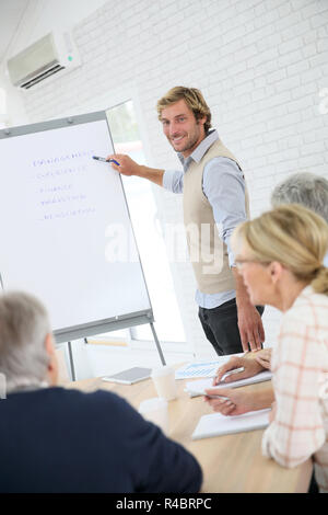 Business instructor leading meeting with senior training group Stock ...