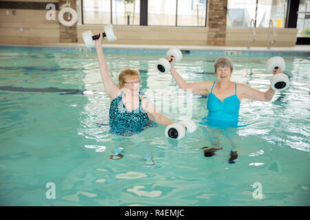 Group of seniors doing water aerobics in a rehab class in the swimming ...