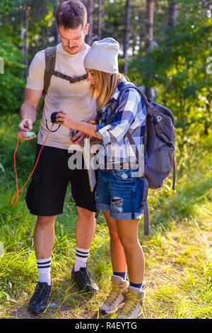Young couple playing music while walking in the forest. Hiking concept ...