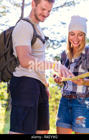 Young couple checking the map and listening music while walking in the ...