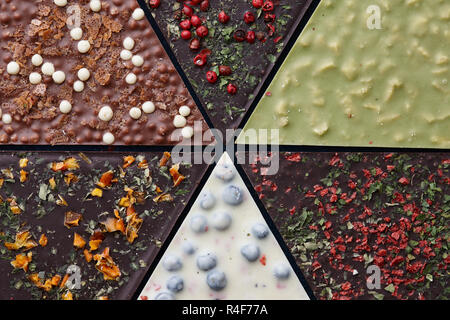 Triangle shaped pieces of handmade chocolate with diverse kinds of ...