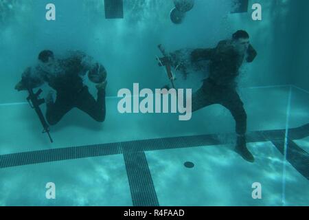 U.S. Marines conduct an underwater gear shed in a pool during a basic ...