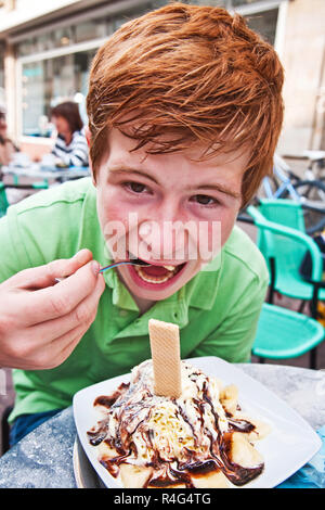 child is eating icecream at a outdoor table Stock Photo - Alamy