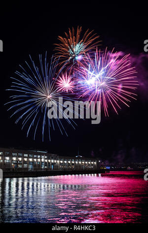Fireworks exploding over the Golden Gate Bridge are partially shrouded ...
