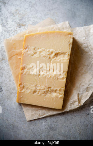 A block of parmesan cheese on parchment paper Stock Photo - Alamy