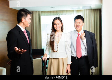 Asian Chinese Hotel Manager or director or supervisor welcome arriving ...
