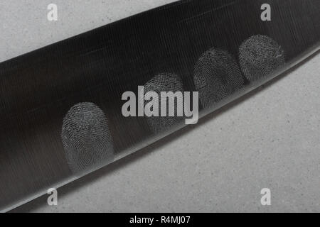 Dusted finger prints showing up as forensic eveidence on a sharp steel ...