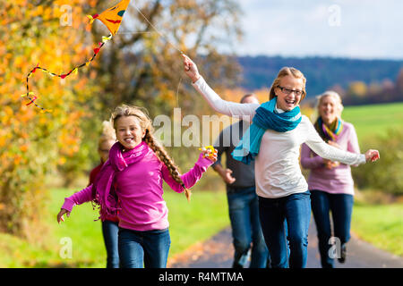 Family take walk in autumn forest flying kite Stock Photo - Alamy