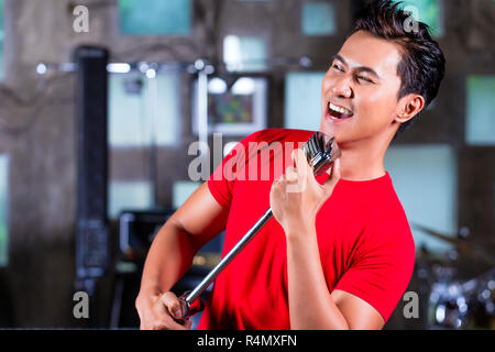 Asian singer producing song in recording studio Stock Photo - Alamy