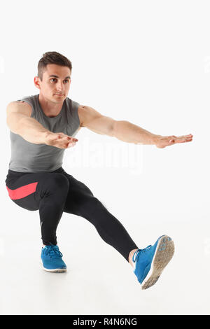 Fitness man crouchs from floor demonstrates Stock Photo - Alamy