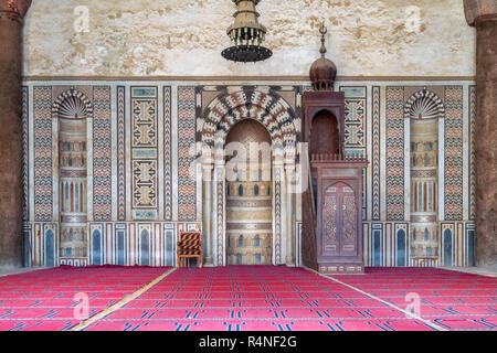 Colorful decorated marble wall with engraved niche (Mihrab) and wooden ...