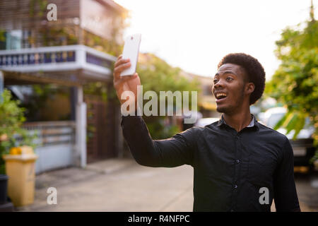 low angle view of curly african american woman in white dress against ...