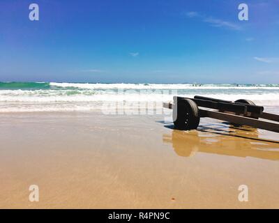 The wheelbarrow on the beach with sea wave foam Stock Photo - Alamy
