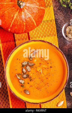 Pumpkin soup in a bowl served with parsley and pumpkin seeds. Vegan ...