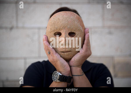A mask from the Neolithic period ( 9,000 years ago) is displayed in the ...