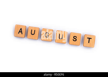 AUGUST, spelt with wooden letter tiles over a plain white background ...