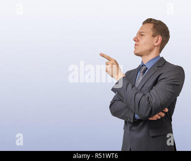 Young businessman points with his finger to his right - isolated with ...