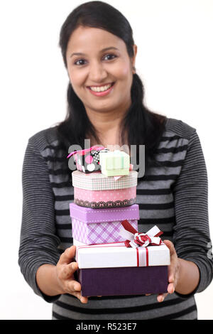Young woman holding boxes against white Stock Photo - Alamy